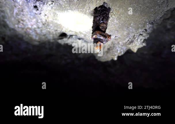 A drop on an old rusty screw in a cave. Wet walls. Macro photography of ...