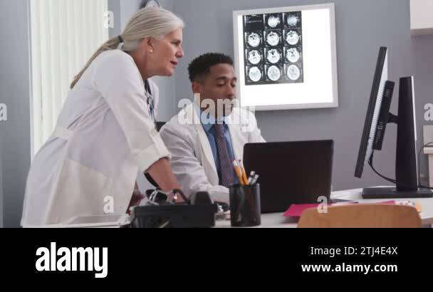 Millennial african-american doctor comparing notes with senior ...