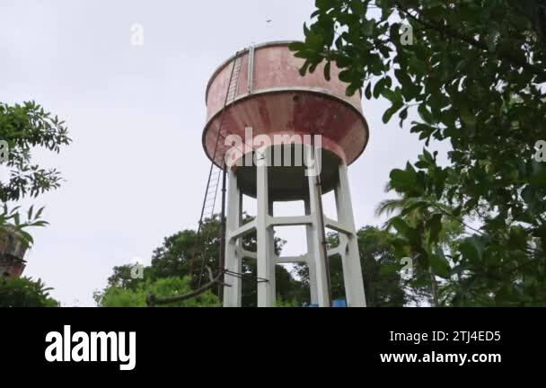 A low-angle view of a water tower in a small Indian village. old water ...