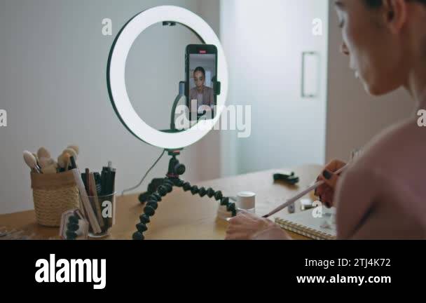 Vlogger girl smartphone streaming applying makeup at home closeup ...
