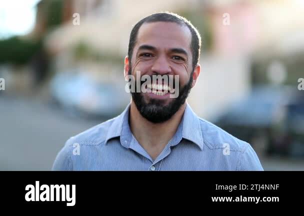 Man smiling and laughing outdoors with lens-flare. Person in 40s smile ...