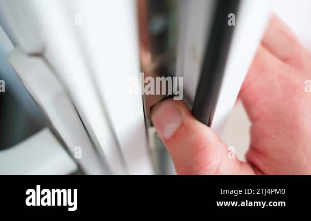 The finger checks the spring mechanism of the latch of the door lock of ...