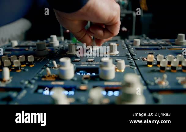 The captain presses the buttons on the control panel to start the ...