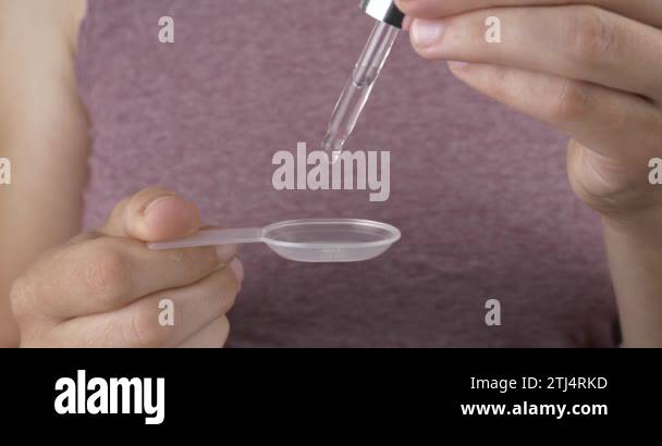medicine drops for colds, woman with pipette drops syrup in a spoon ...