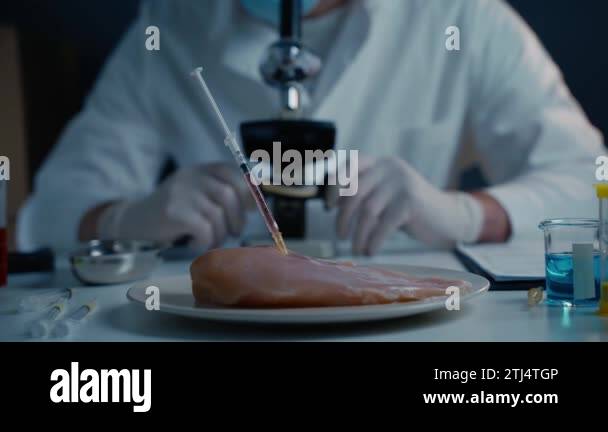 Lab assistant testing GMO chicken. Worker of food quality control ...