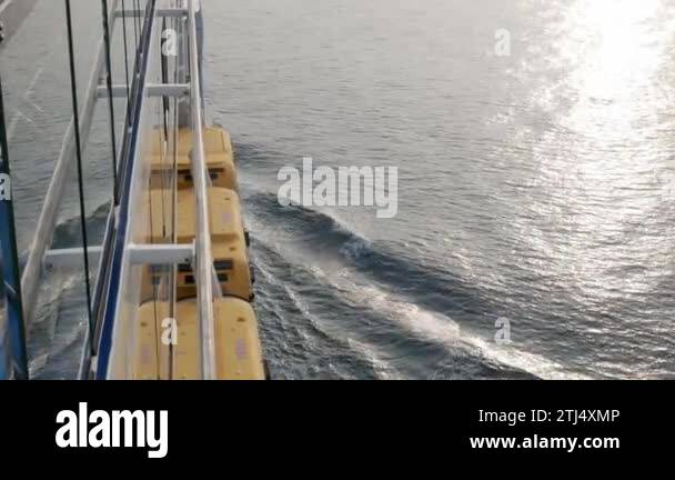 Lifeboat on giant cruise ship view down to ocean surface with waves ...