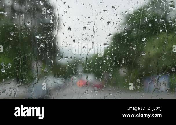 Rain on glass of a bus or car. Raindrops run down the window ...