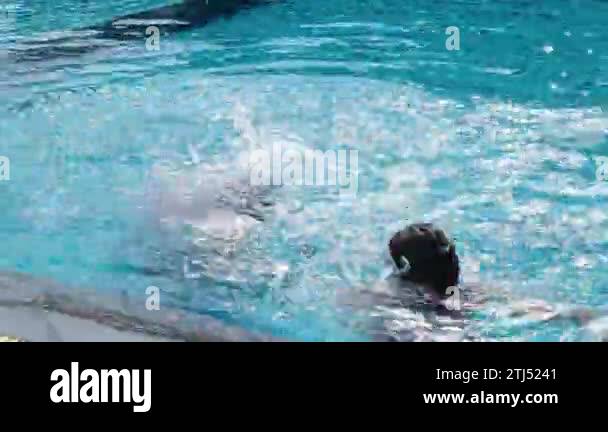 Happy little sisters play in outdoor swimming pool of tropical resort ...