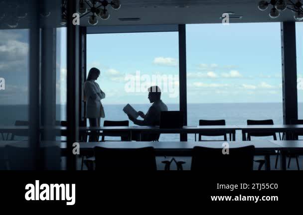 Office secretary showing businessman documents at panorama window ...