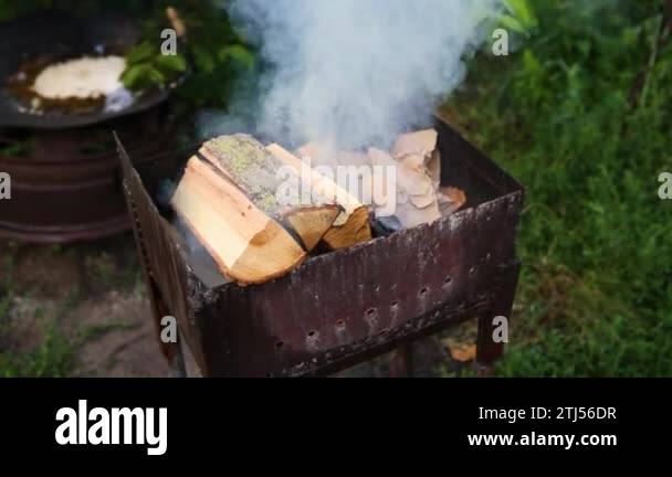Firewood is burning in the grill in outdoor. Kindling firewood on a ...