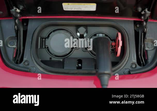 CLOSE UP: Opening charging port and plugging electric cable in ...