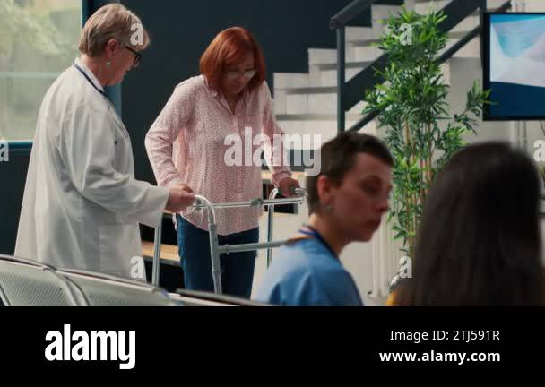 Old doctor helping woman with leg fracture to recover from impairment ...