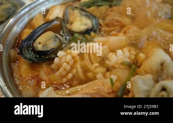 close up to boiling Korean Kimchi tteok pokki soup full with pork,squid ...