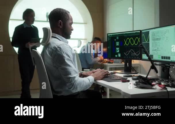 Side view of African American engineer working on innovation project in ...