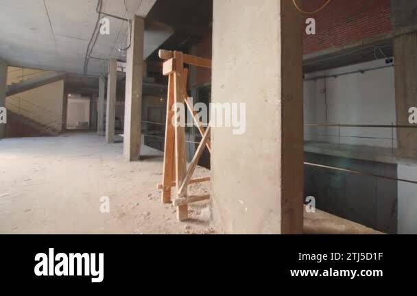 Wooden scaffold on empty concrete ground in renovated plant building ...