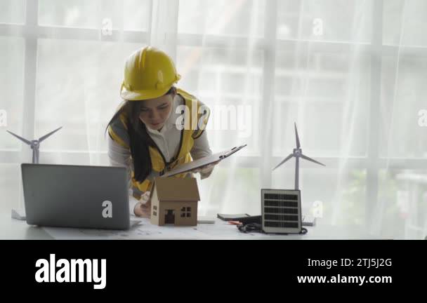 Asian female engineers are planning a power plant with blueprints in ...