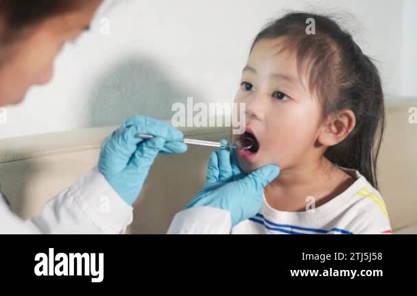 Dental kid health examination. Asian dentist making examination procedure for cute little girl ...