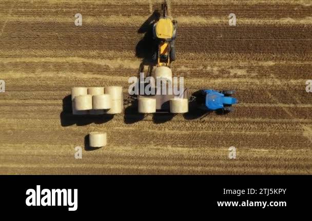 Above top view, dolly move upwards over excavator as loading straw ...