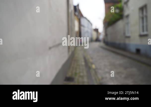 Out of focus background plate of alley with cobblestone street in ...