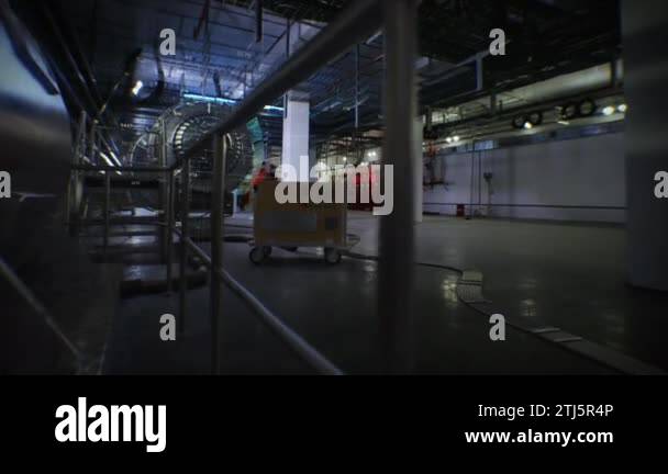 Team of heavy industry workers walk through metal pipes on gas ...