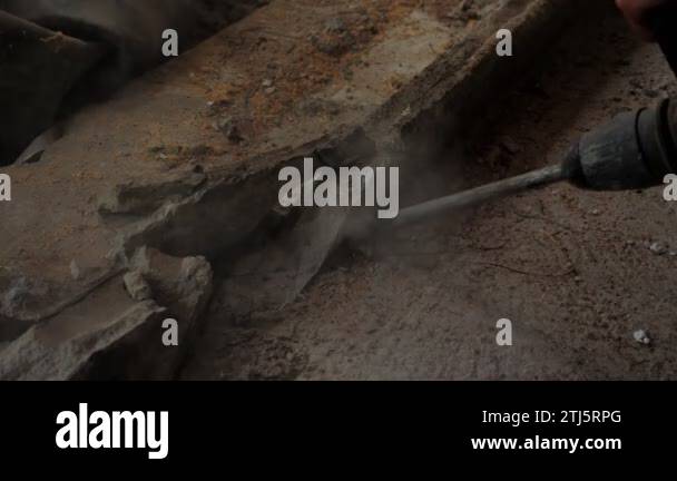Drill bit breaks the concrete on demolition site. Builder worker using ...