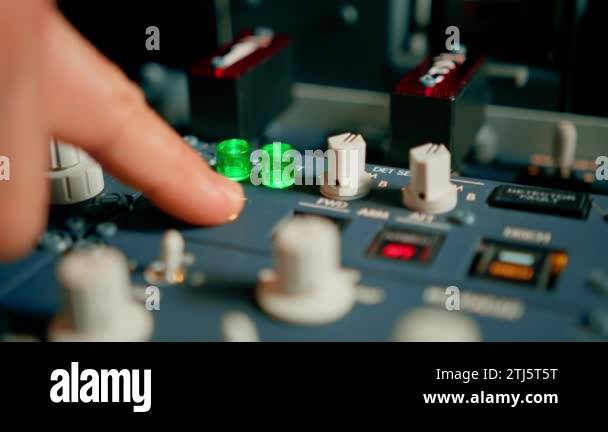The captain presses the buttons on the control panel to start the ...
