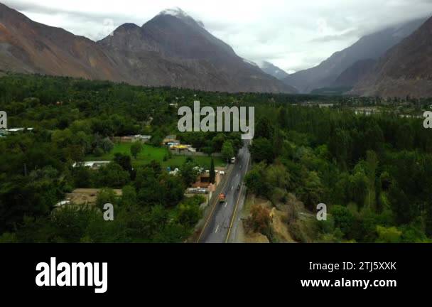 Dramatic drone shot following a tuk-tuk on the Karakoram Highway ...