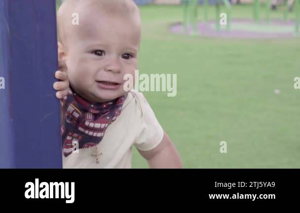 Baby boy standing outside. Little Baby is crawling on green grass ...