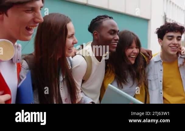 Happy diverse group of student friends laughing together at college ...