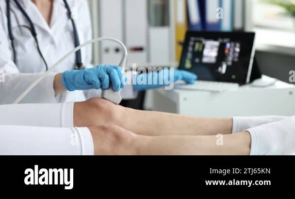 Doctor performs ultrasound of knee joint in clinic. Ultrasound of knee ...