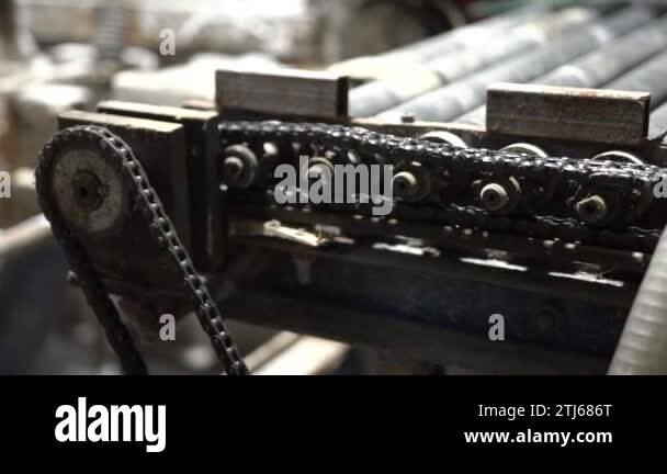 Closeup of rotating gears and chains on industry machine conveyor ...