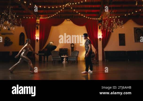 Asian woman in shiny glamorous golden suit jumping high performing a ...