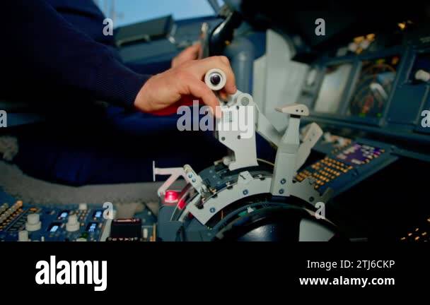 Close-up of a pilot's hand pressing the throttle in the cockpit of jet ...