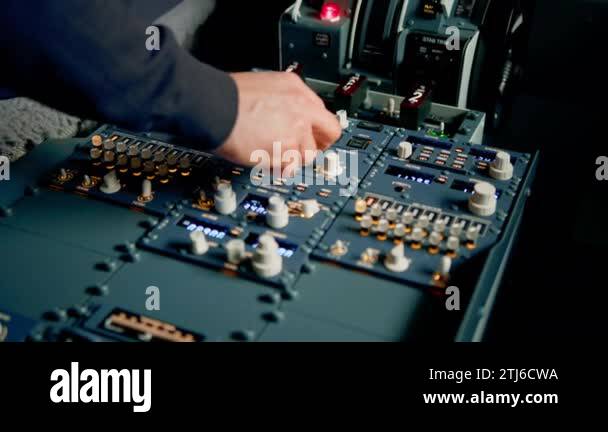 The captain presses the buttons on the control panel to start the ...