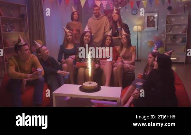 Friends in festive hats congratulate the birthday girl on her birthday ...