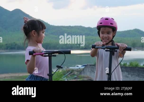 Two cute little girls smiling and posing together in summer garden ...