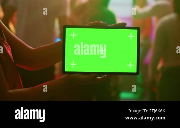 Adult using tablet with green screen at club, holding gadget with blank ...