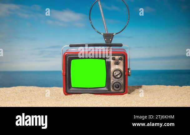 A vintage television on the beach with green screen to add any content ...