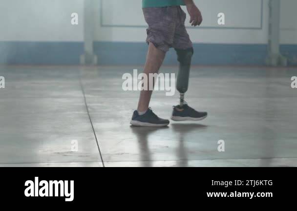Disabled person walking with his prosthetic leg indoors. Amputee man ...