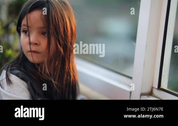 Little girl portrait staring out window Stock Video Footage - Alamy