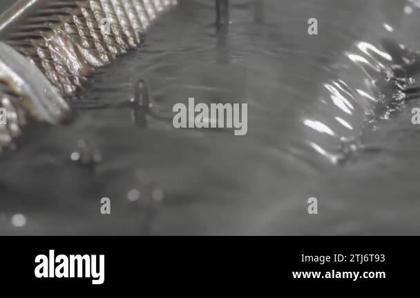 Lifting the submerged part of the engine from the cleaning solution in ...