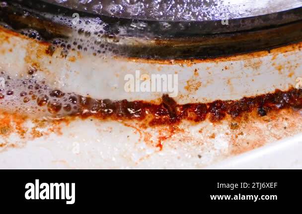 A very dirty old kitchen electric stove with a burnt coating is ...