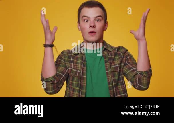 Excited amazed man 20s in shirt touching head and showing explosion ...