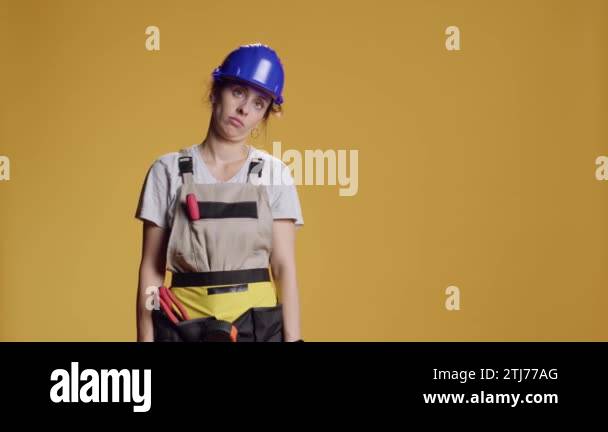 Portrait of female builder being hit in head and feeling dizzy, seeing ...