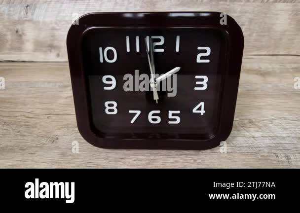 Timelapse analog clock on wooden table shows time. Mechanical modern ...