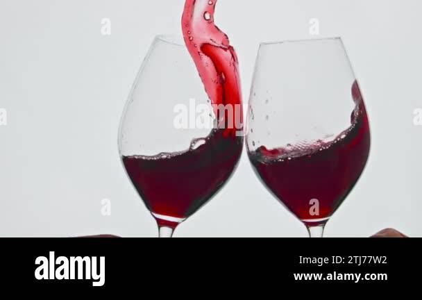 Clinking raising red beverage vessels closeup. Rose wine splashing over ...
