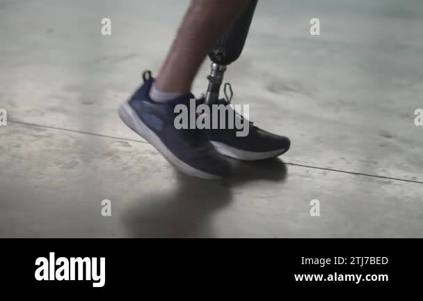 Disabled person walking with his prosthetic leg indoors. Amputee man ...
