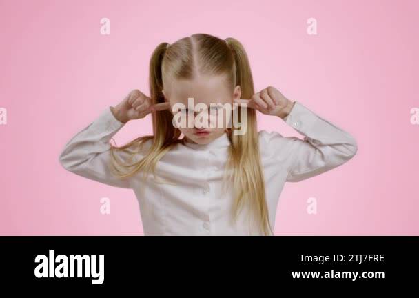 Kids caprices. Portrait of grumpy little girl closing ears with fingers ...