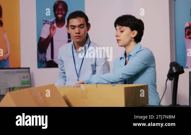 Diverse store managers preparing packages for shipping, putting stylish ...