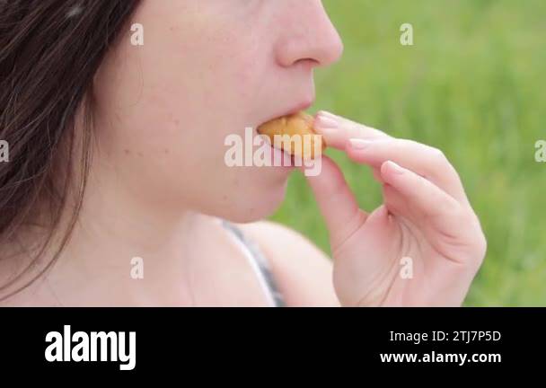 The girl eats chicken strips or nuggets. Hungry young woman eating fast ...